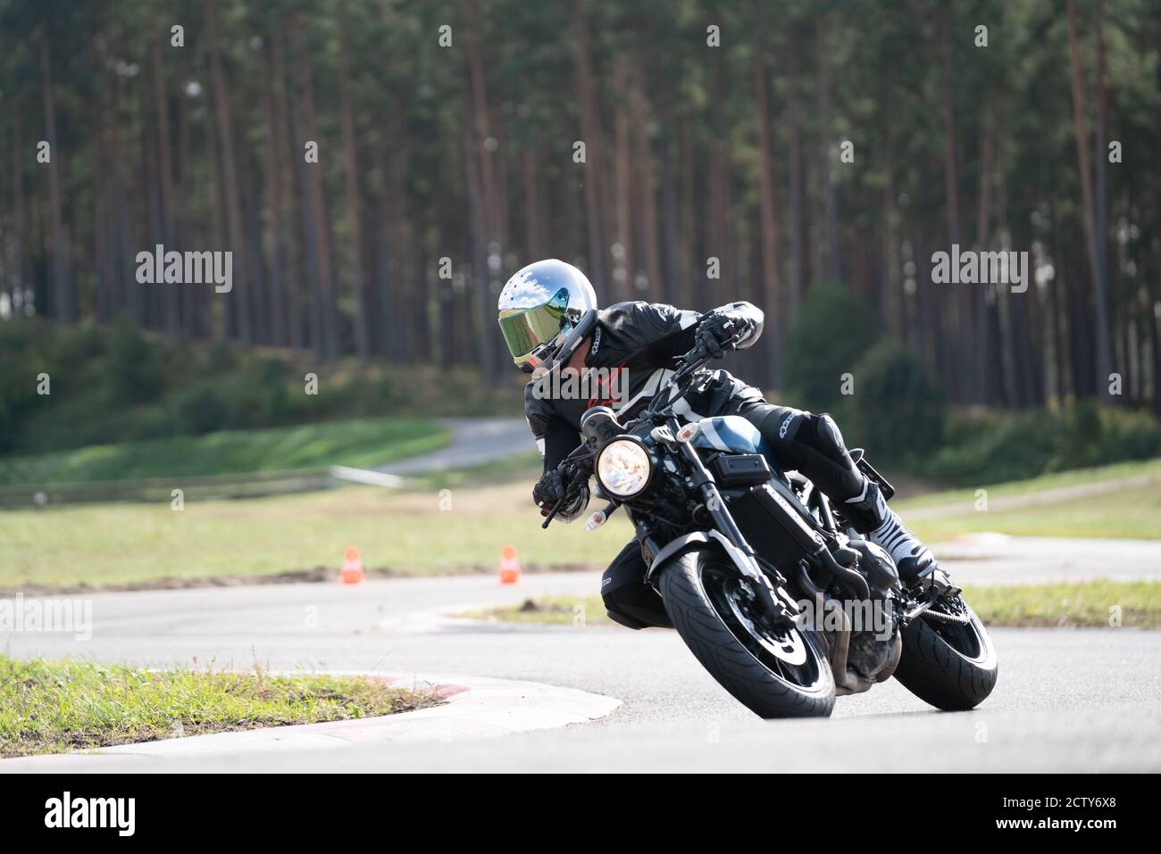 Motorcycle practice leaning into a fast corner on track Stock Photo - Alamy