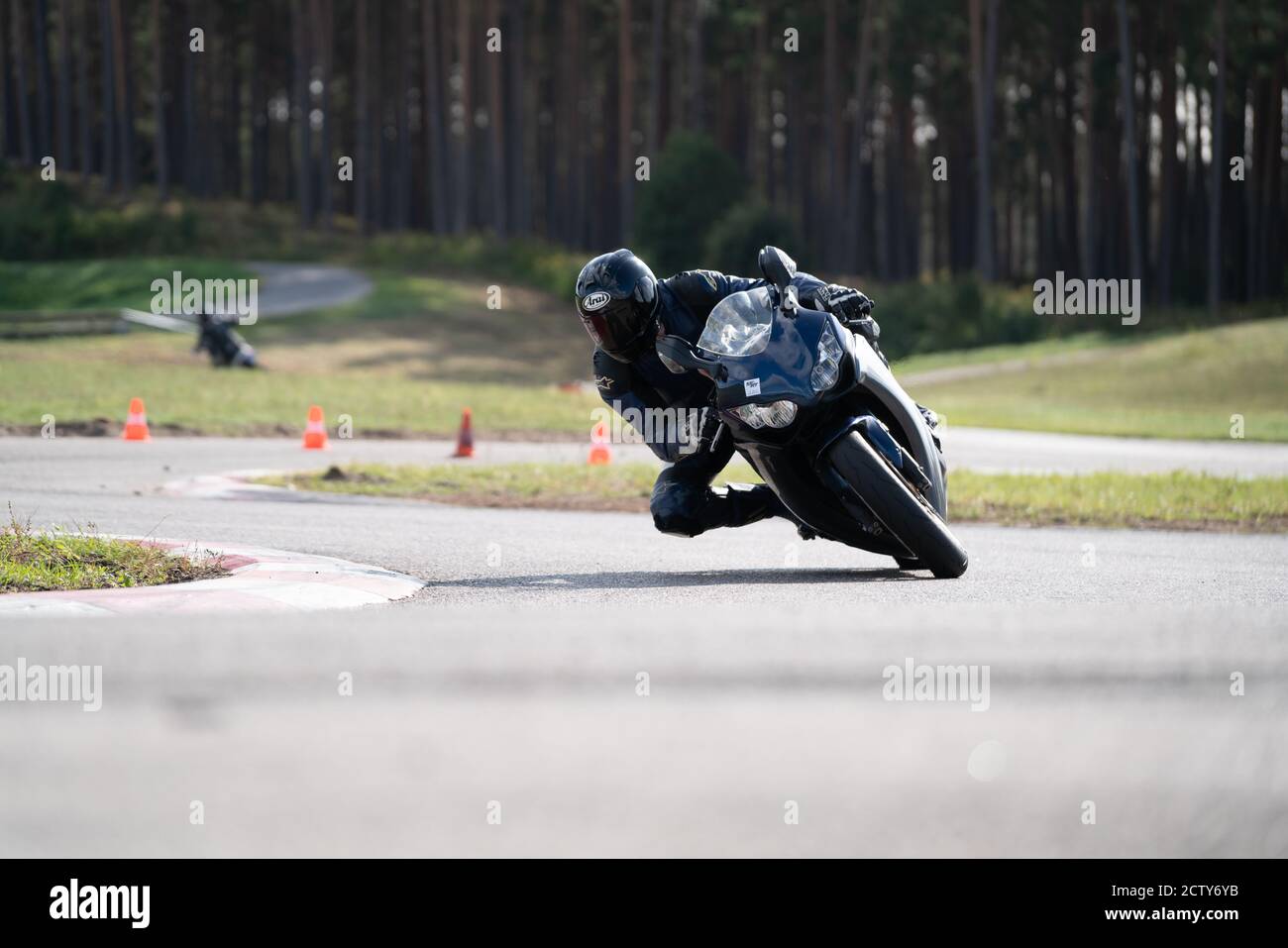 Motorcycle practice leaning into a fast corner on track Stock Photo - Alamy