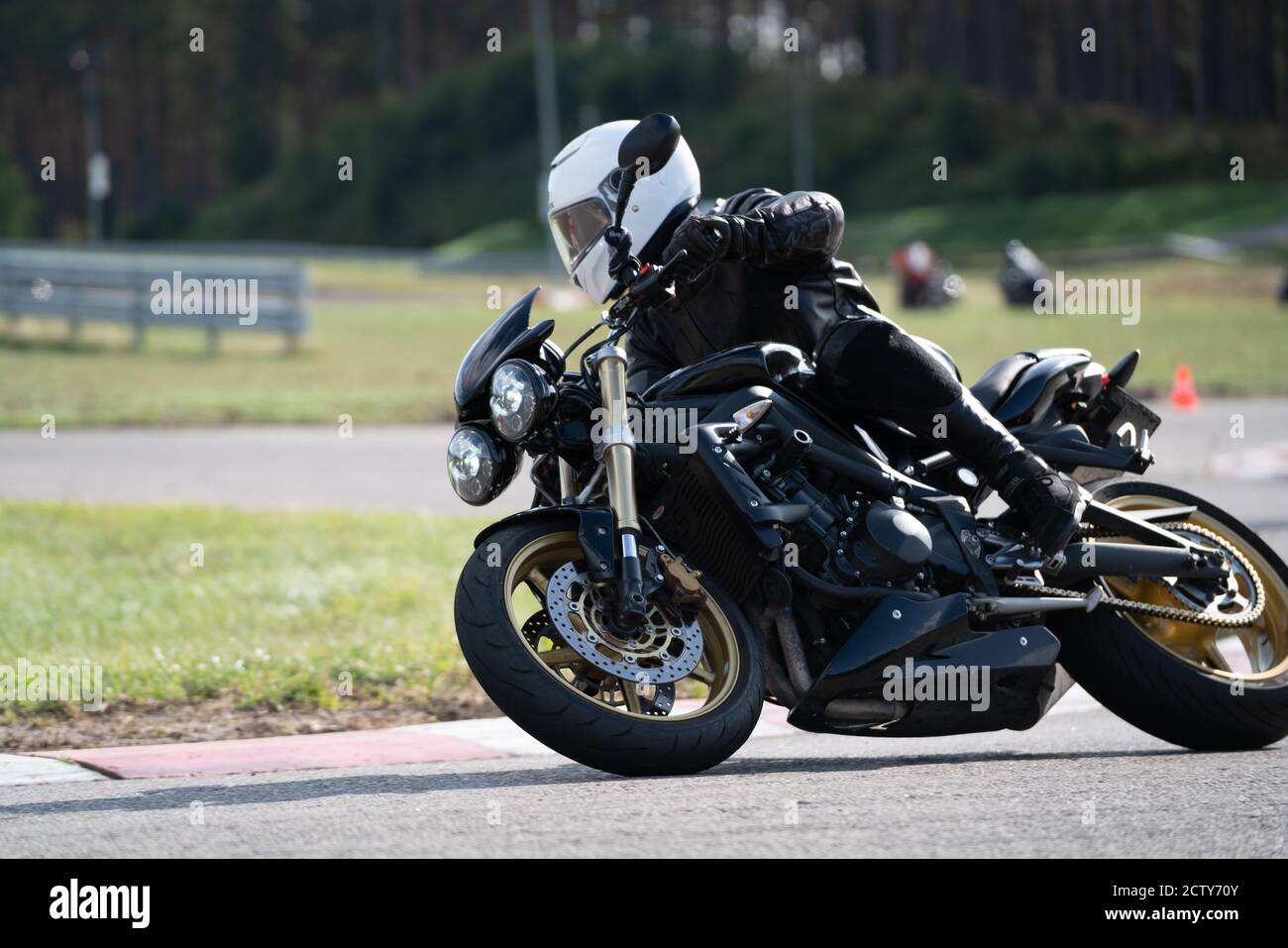 Motorcycle practice leaning into a fast corner on track Stock Photo - Alamy