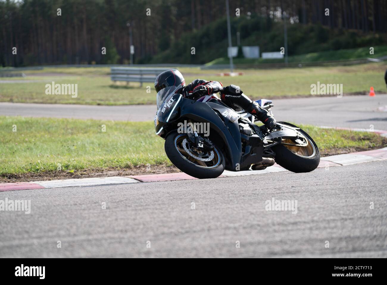 Motorcycle practice leaning into a fast corner on track Stock Photo - Alamy
