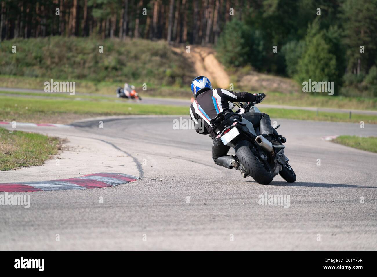 Motorcycle practice leaning into a fast corner on track Stock Photo - Alamy