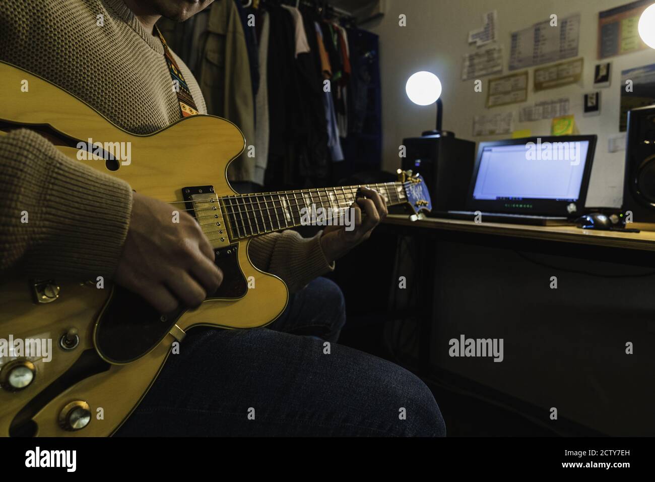 Musician working at his home studio by playing guitar Stock Photo - Alamy