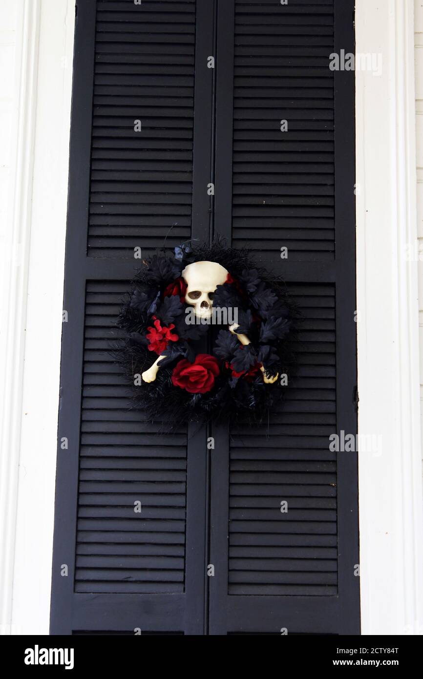 an elegant Halloween wreath with a faux skull and red roses on black ...