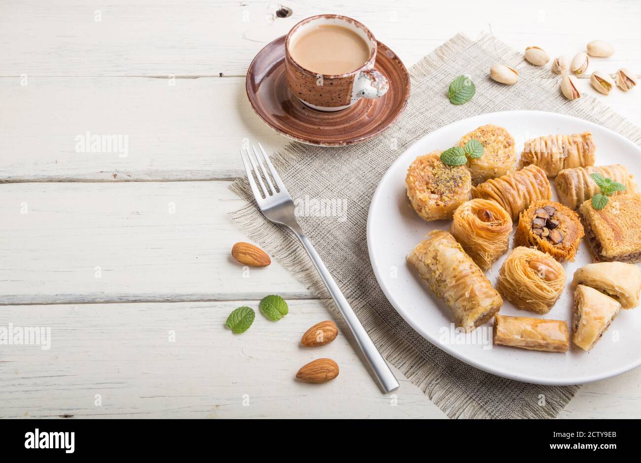traditional arabic sweets (kunafa, baklava) and a cup of coffee on a ...