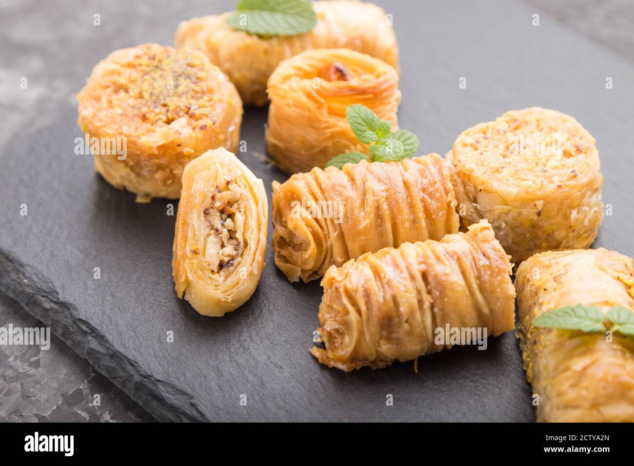 traditional arabic sweets (kunafa, baklava) on a black slate board on a ...