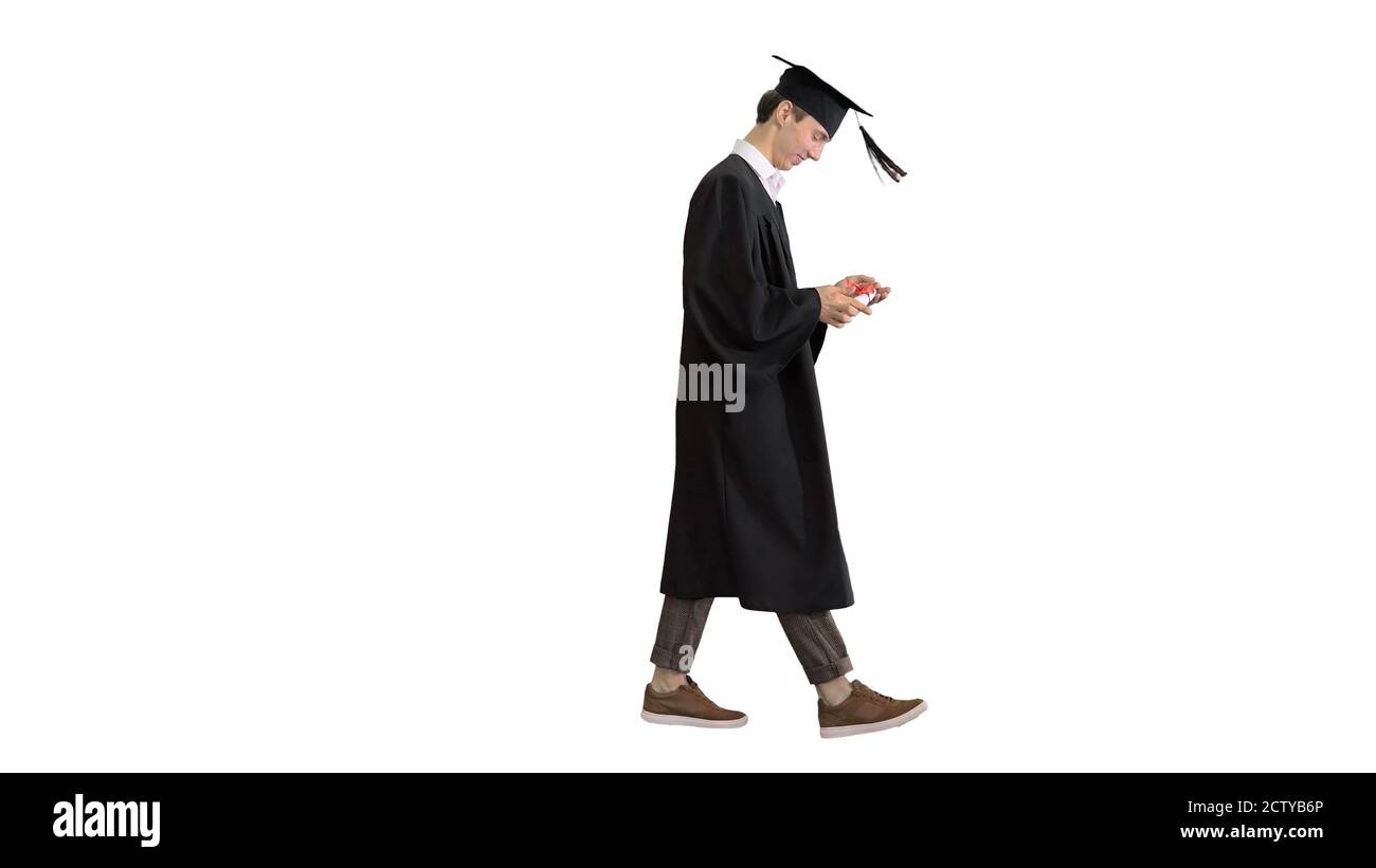 Graduate student walking and smiling on white background Stock Photo ...