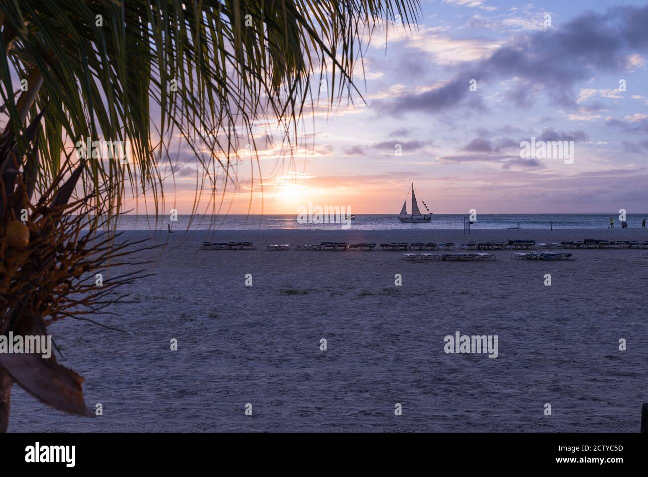 Tropical white beach in Coche island during sunset with a sailing ship ...