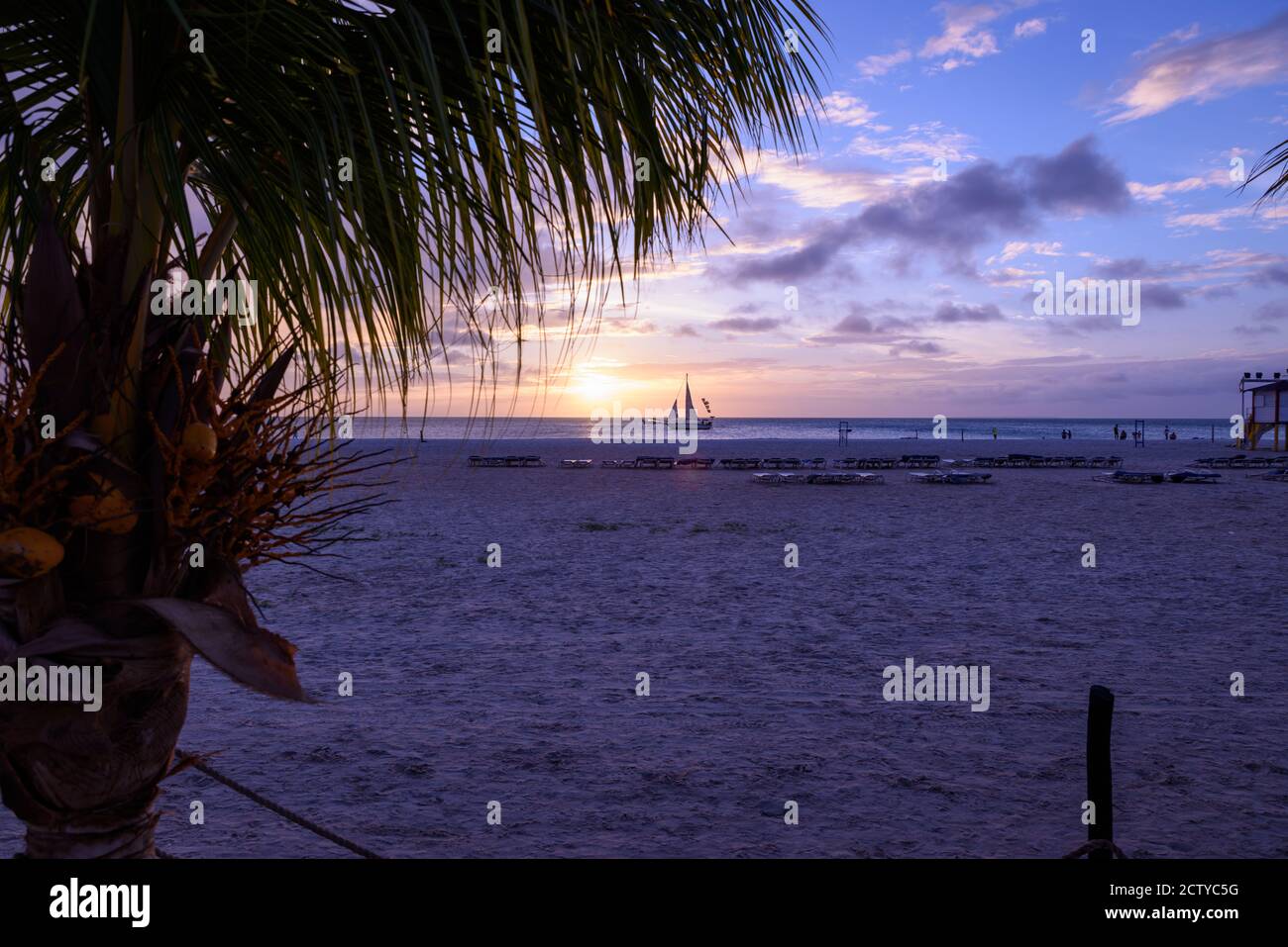 Tropical white beach in Coche island during sunset with a sailing ship ...
