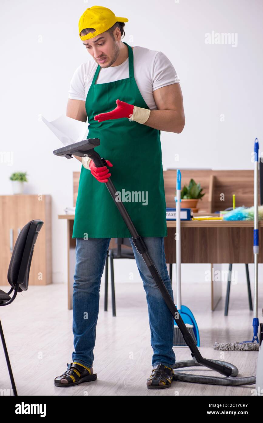 Young contractor cleaning the office Stock Photo - Alamy