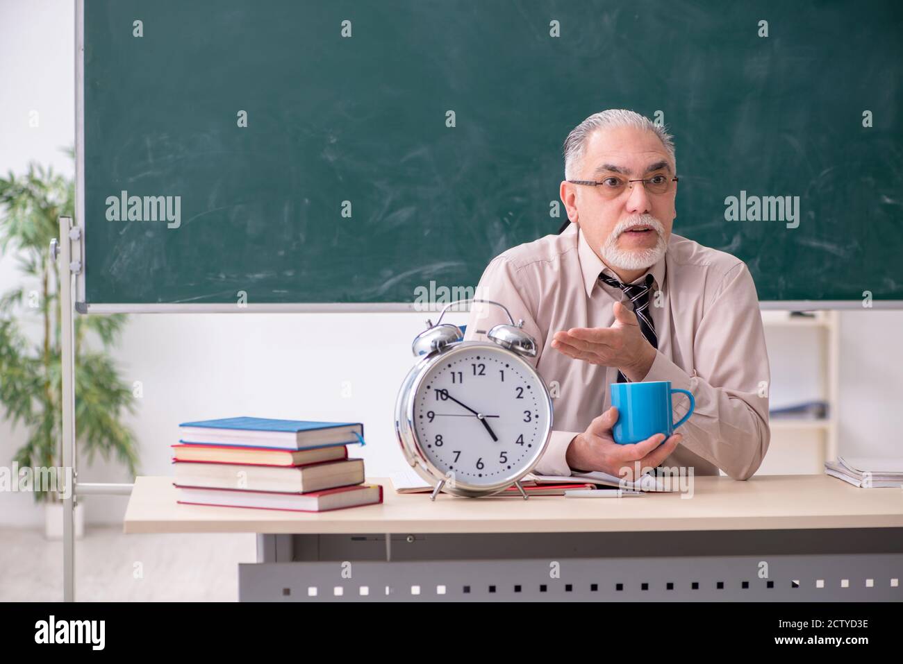 Old experienced teacher in the classroom Stock Photo - Alamy