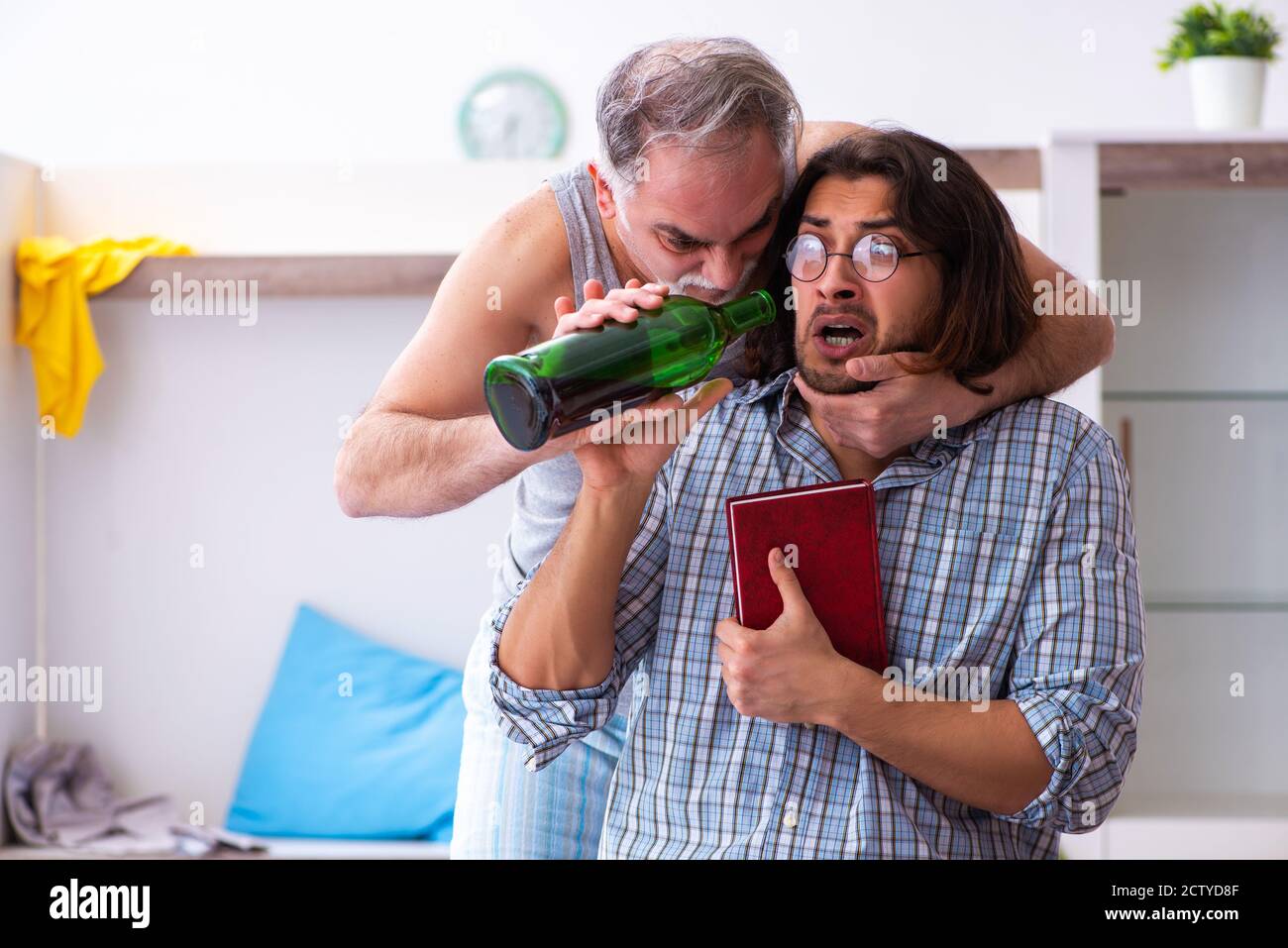 Young son student and dad alcoholic at home Stock Photo - Alamy