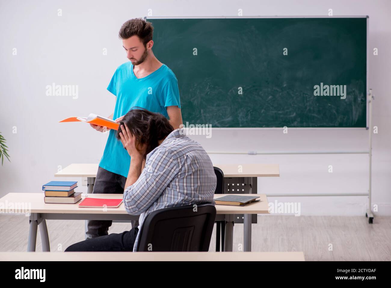 Male pupils in bullying concept in the classroom Stock Photo - Alamy