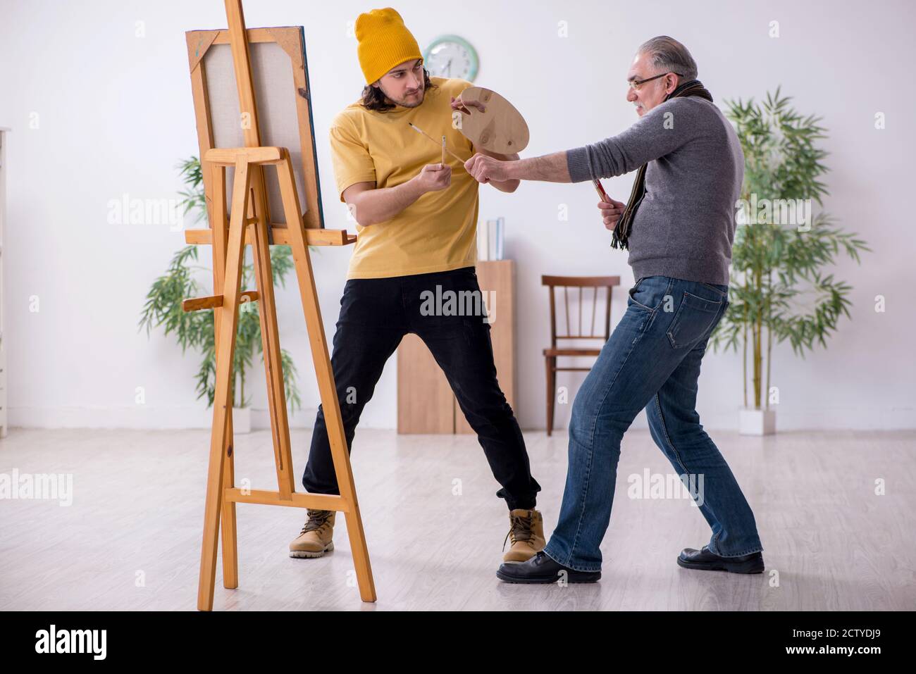 Old man taking lesson from younger painter Stock Photo - Alamy