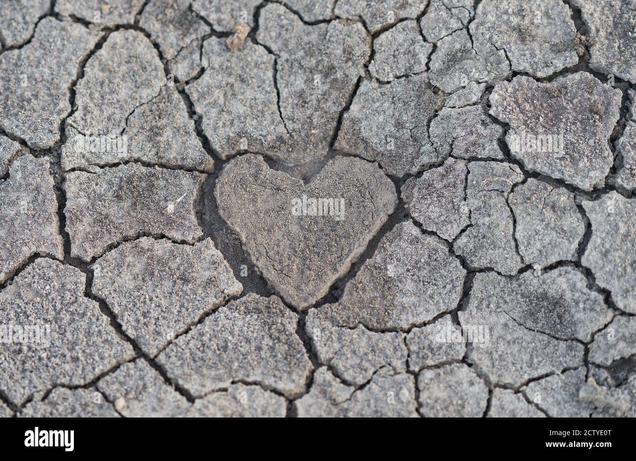 Dry cracked earth with a heart shaped center Stock Photo - Alamy
