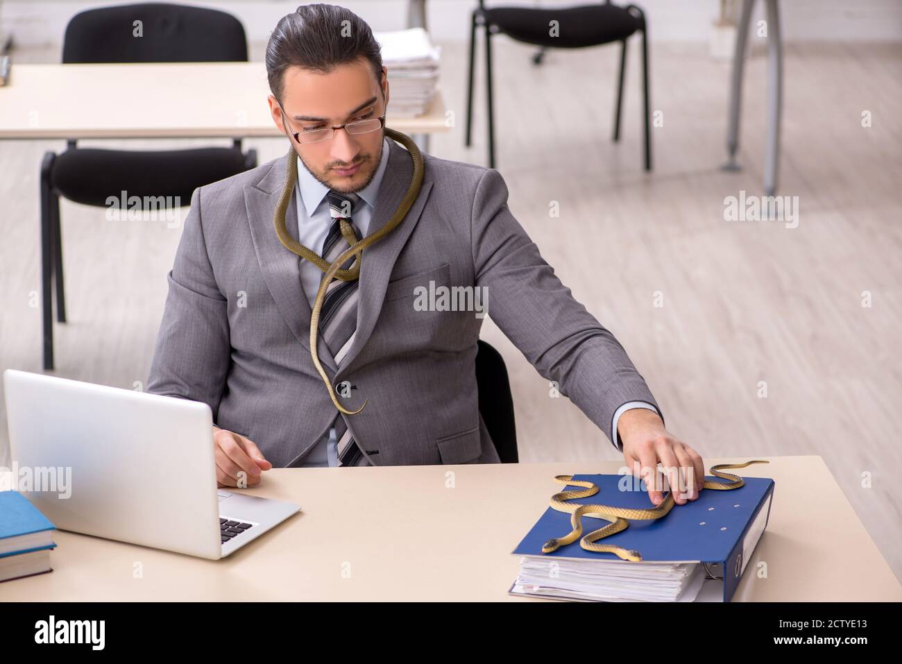 Male employee with snake in the office Stock Photo - Alamy