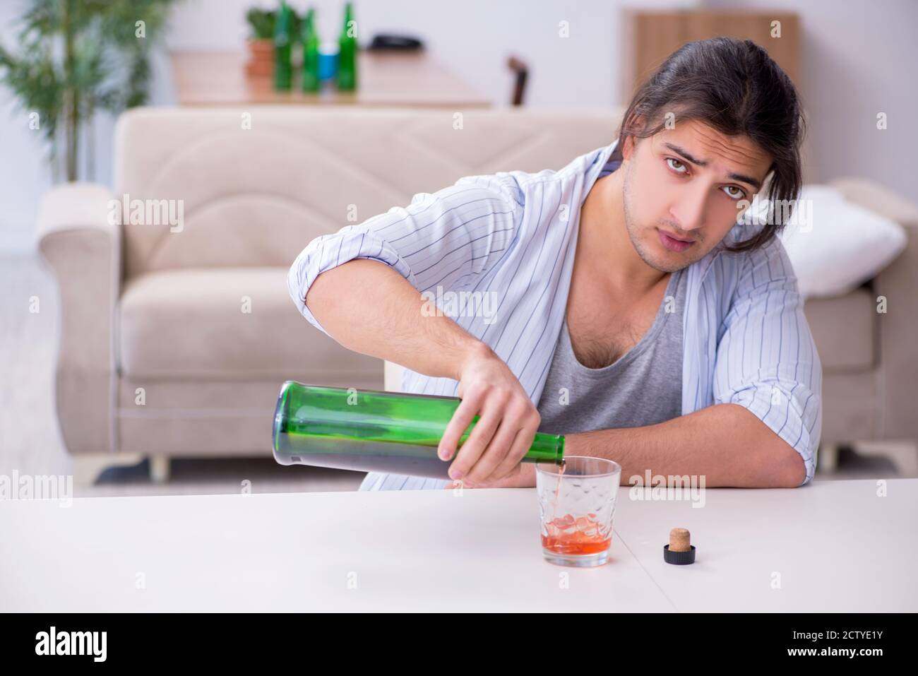 Male alcoholic drinking whiskey at home Stock Photo - Alamy