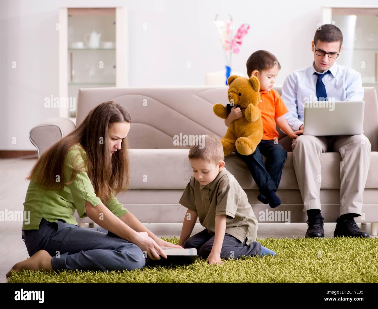 The father is trying to work while children are playing Stock Photo - Alamy