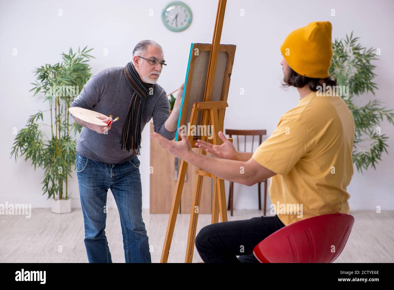 Old portraitist and younger male model Stock Photo - Alamy