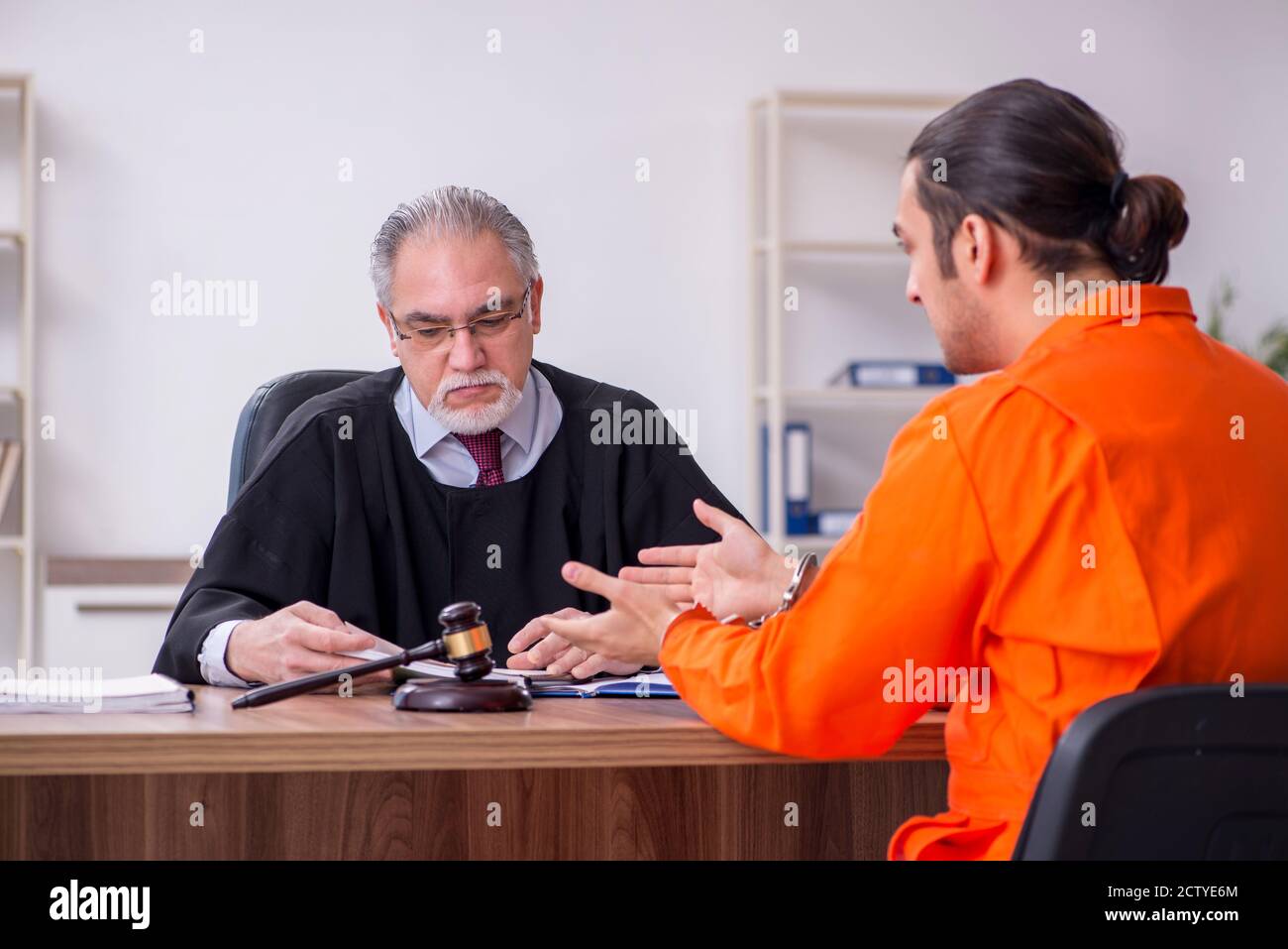 Old judge meeting with young captive in courthouse Stock Photo - Alamy