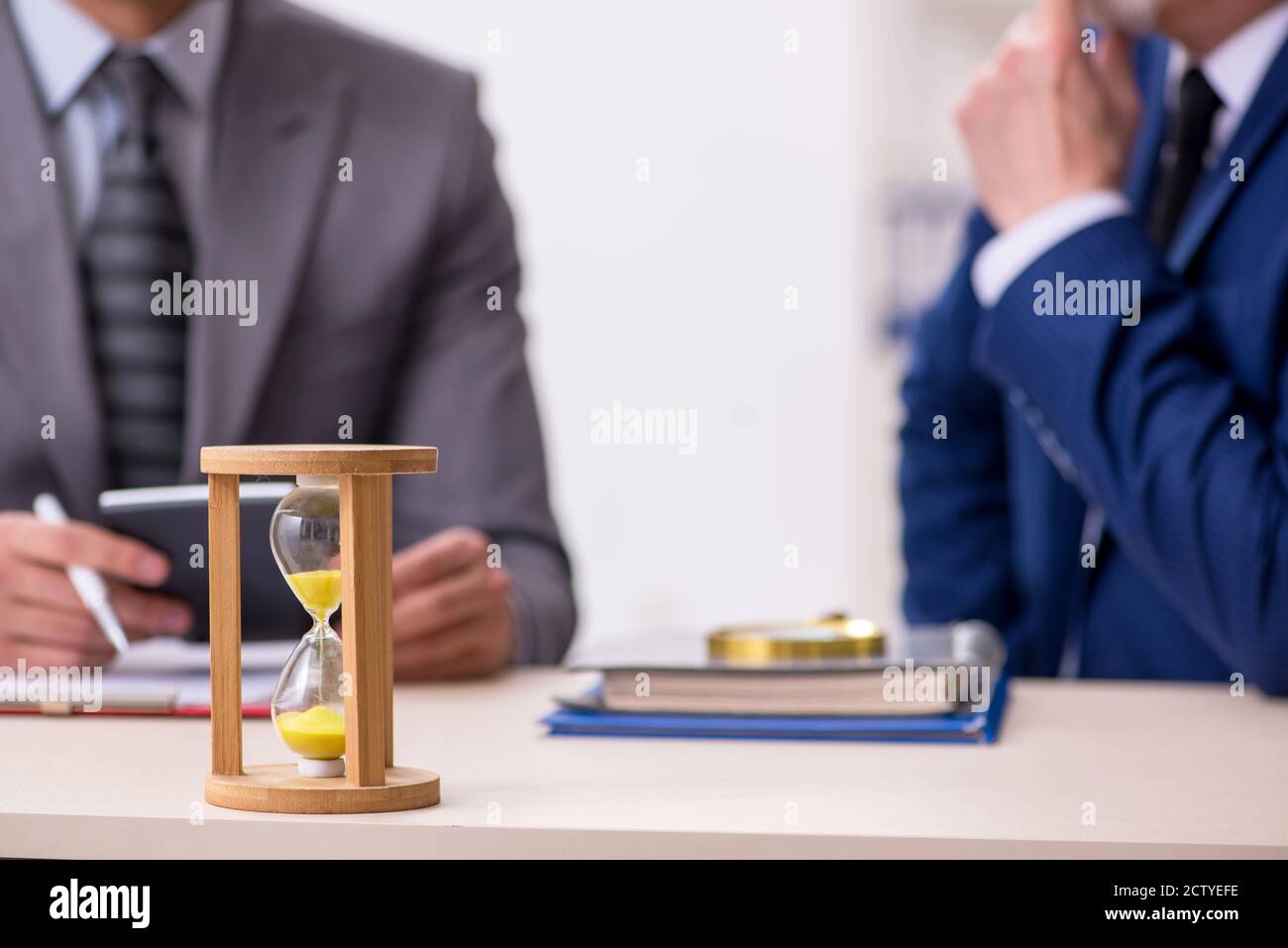 Two businessmen in the time management concept Stock Photo - Alamy