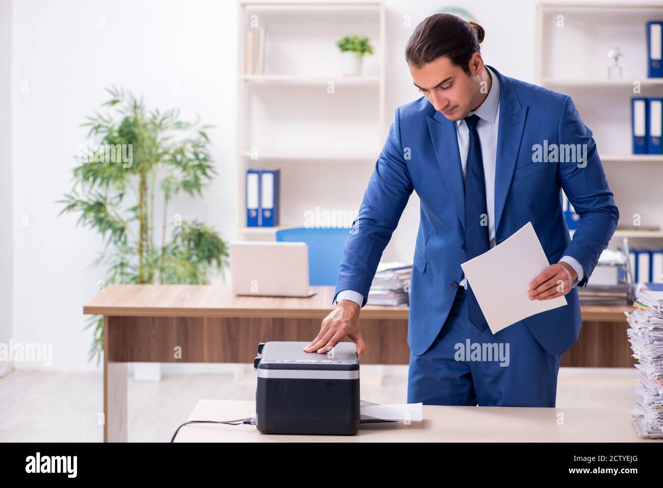 Young employee making copies at copying machine Stock Photo - Alamy