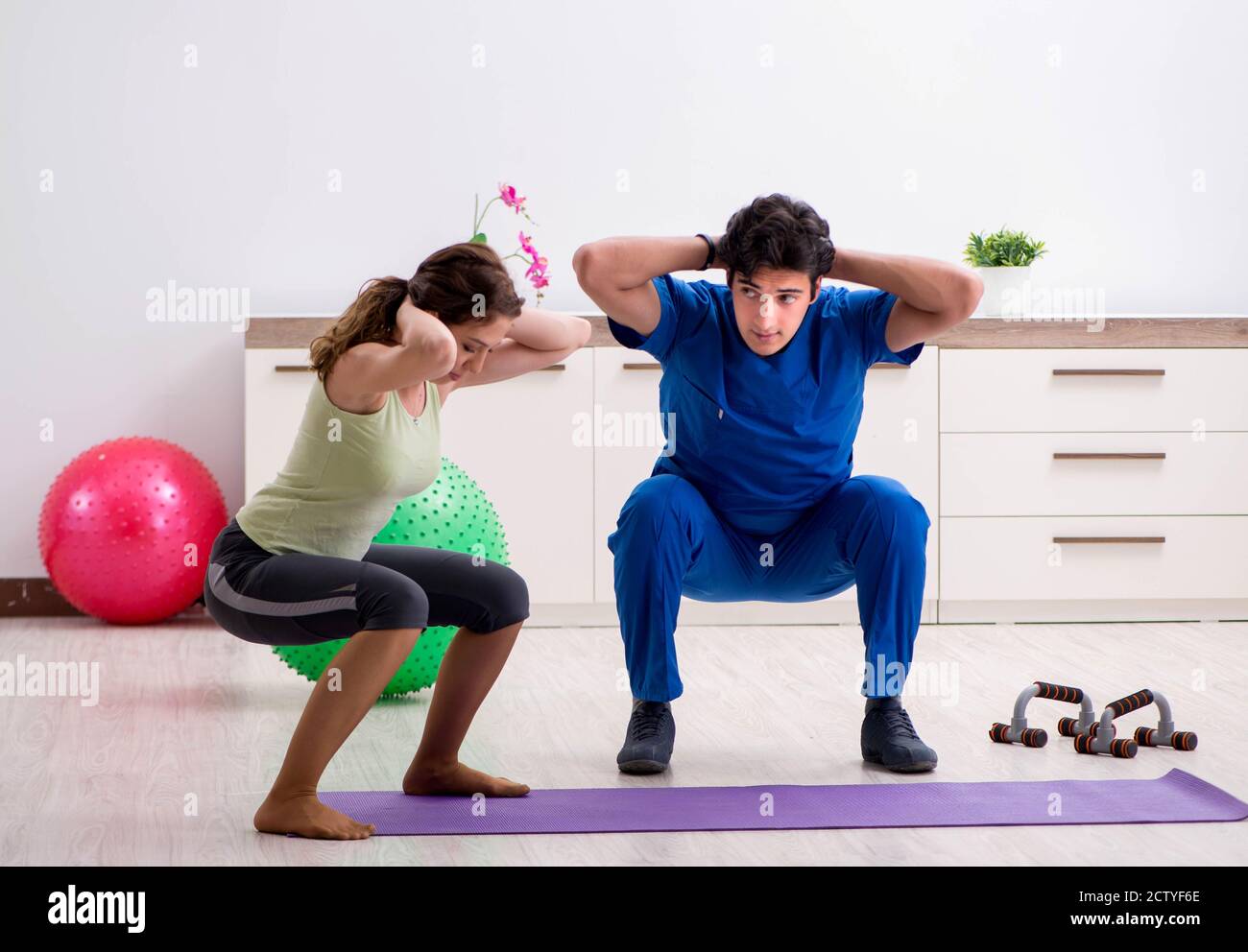The fitness instructor helping sportsman during exercise Stock Photo ...