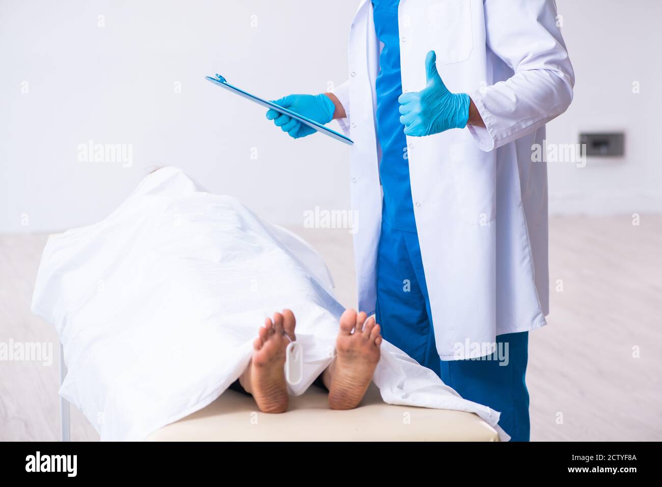 Police coroner examining dead body in morgue Stock Photo - Alamy