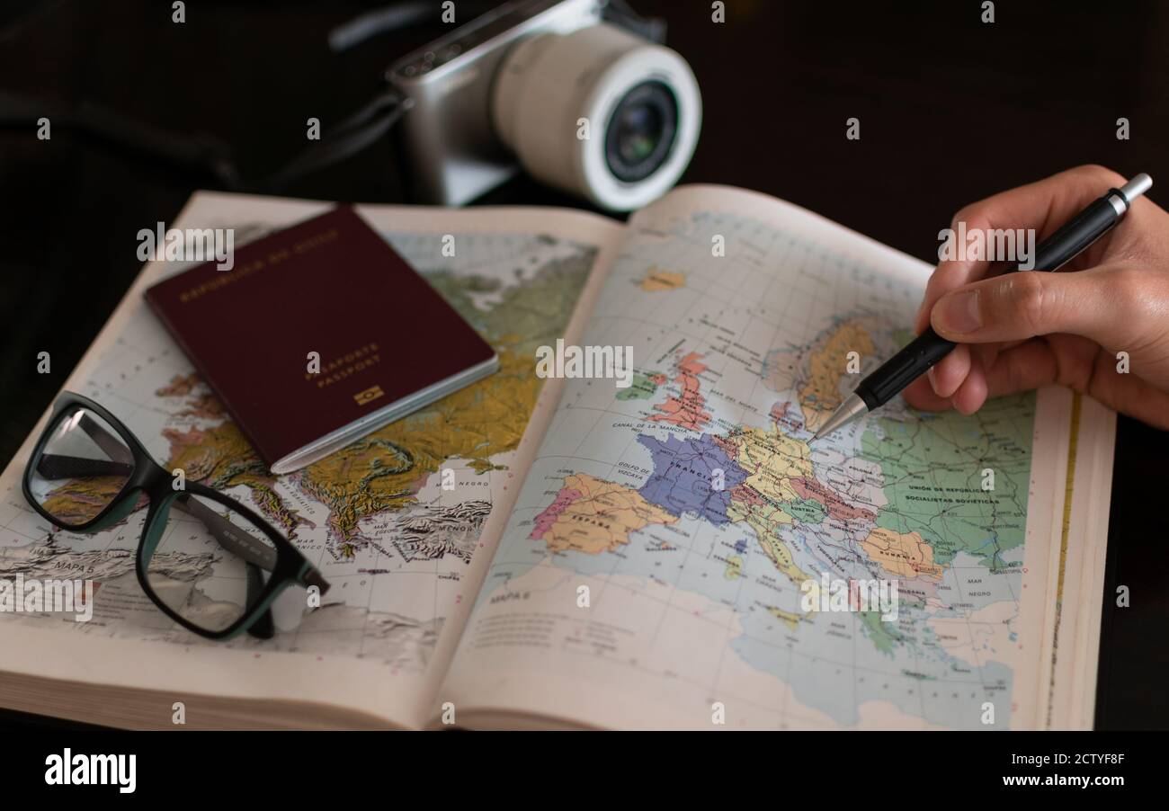 Planning a trip with a map. Camera, passport and a hand marking places ...