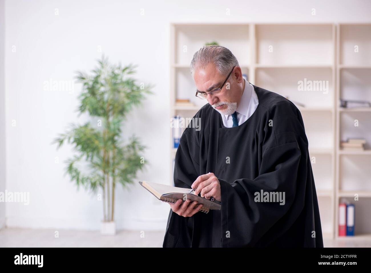 Old male judge working in the courthouse Stock Photo - Alamy
