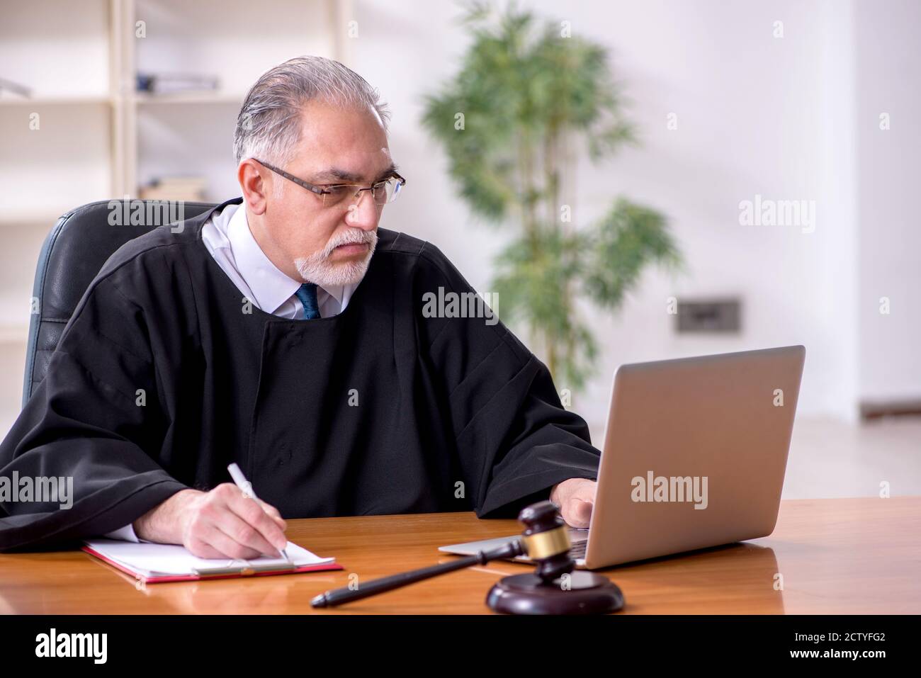 Old male judge working in the courthouse Stock Photo - Alamy