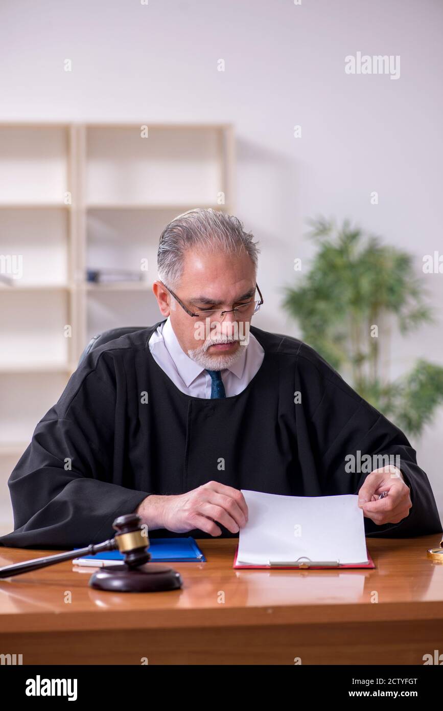 Old male judge working in the courthouse Stock Photo - Alamy