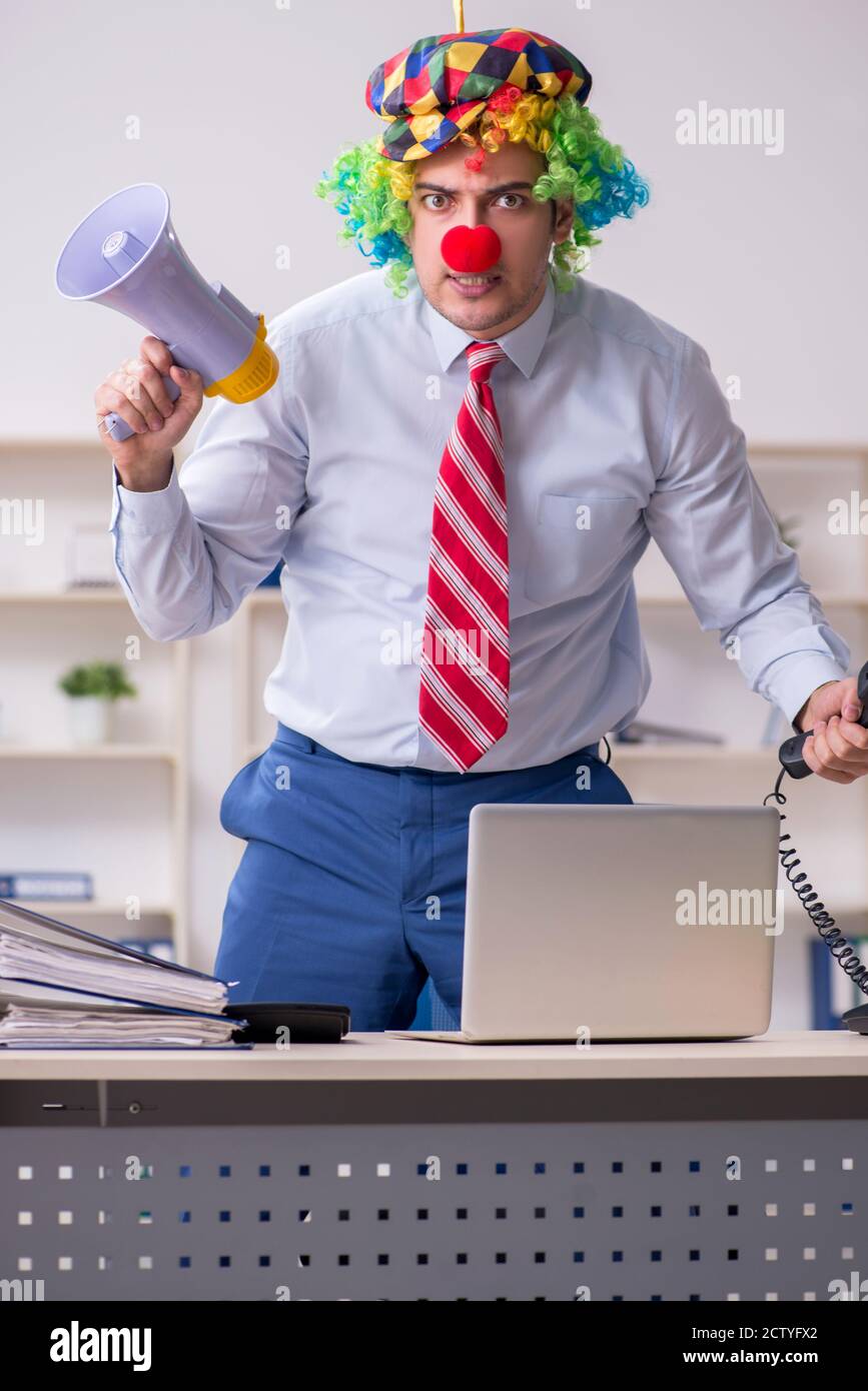 Funny employee clown working in the office room Stock Photo - Alamy