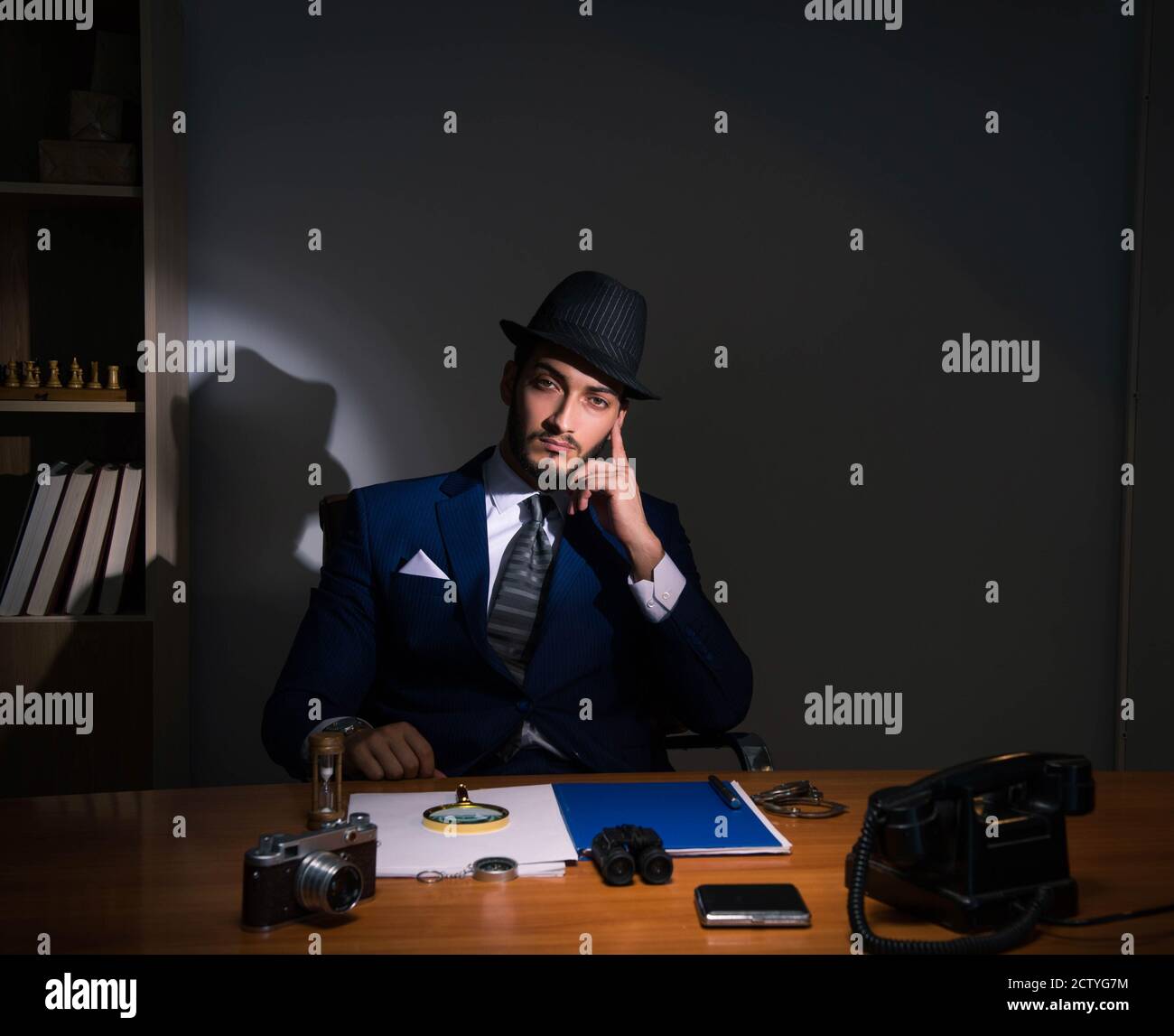 The detective sitting in dark room in vintage concept Stock Photo - Alamy