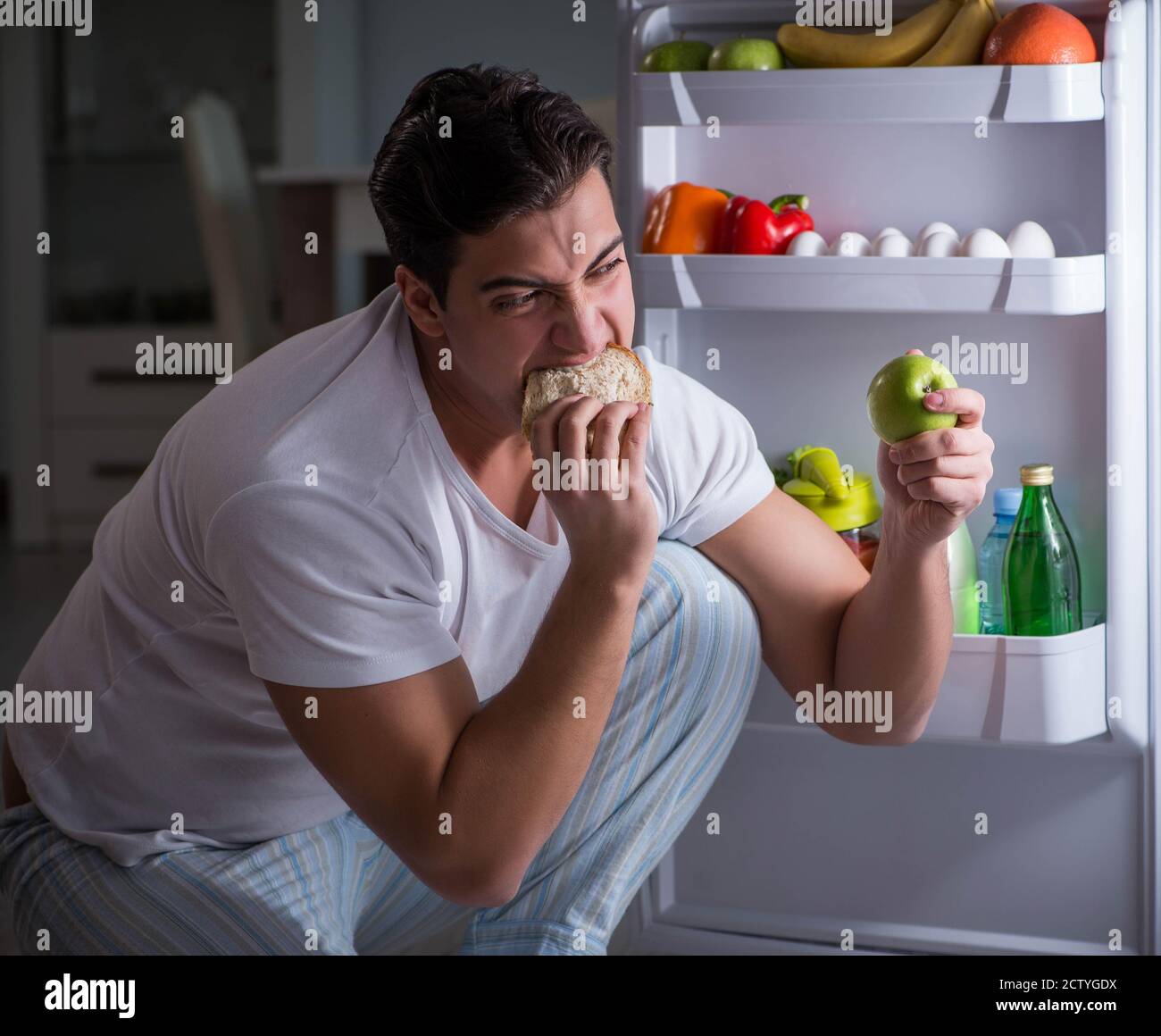 The man at the fridge eating at night Stock Photo - Alamy