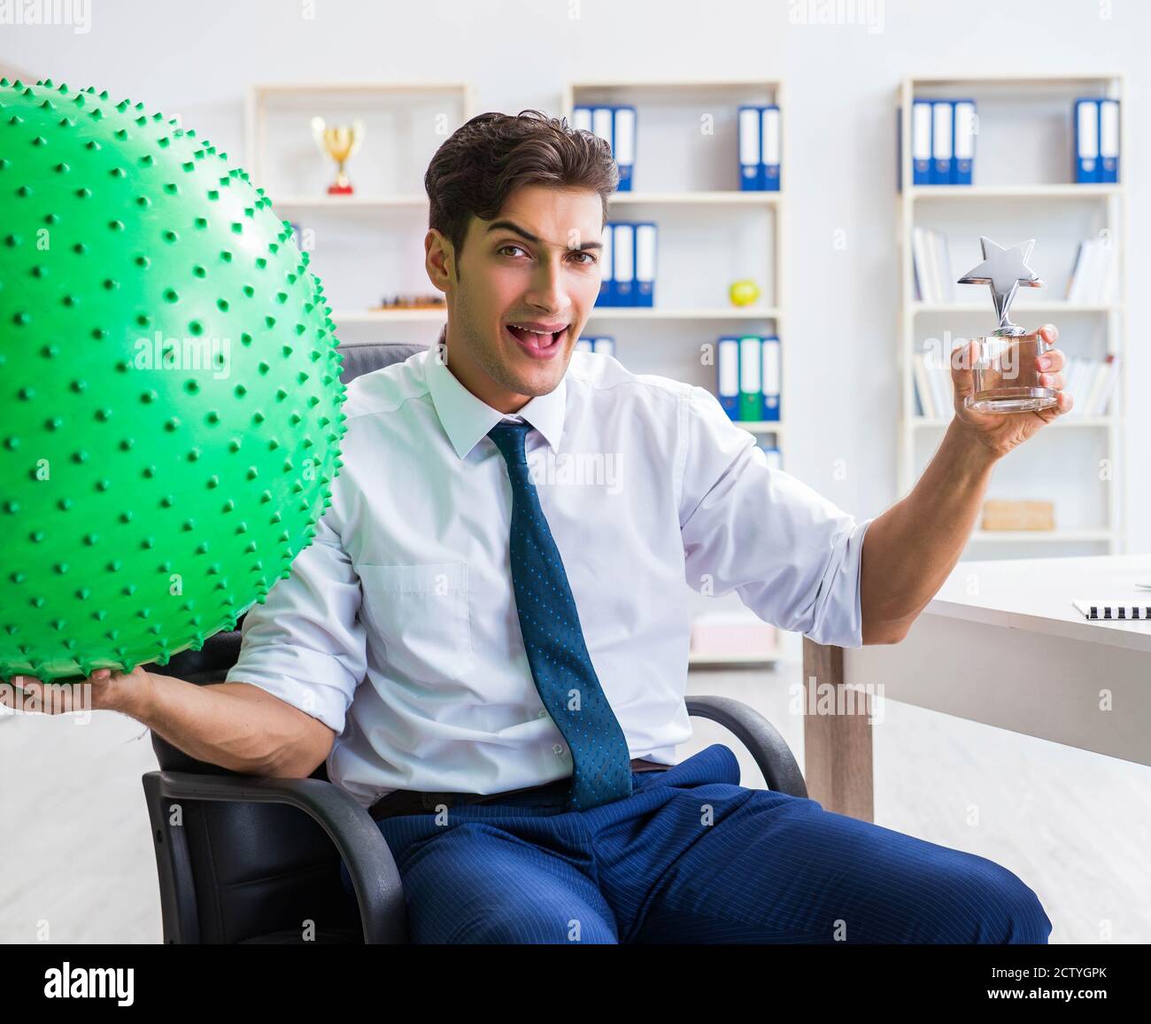 The young businessman doing sports stretching at workplace Stock Photo ...