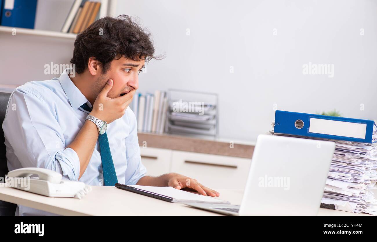 The overloaded busy employee with too much work and paperwork Stock ...
