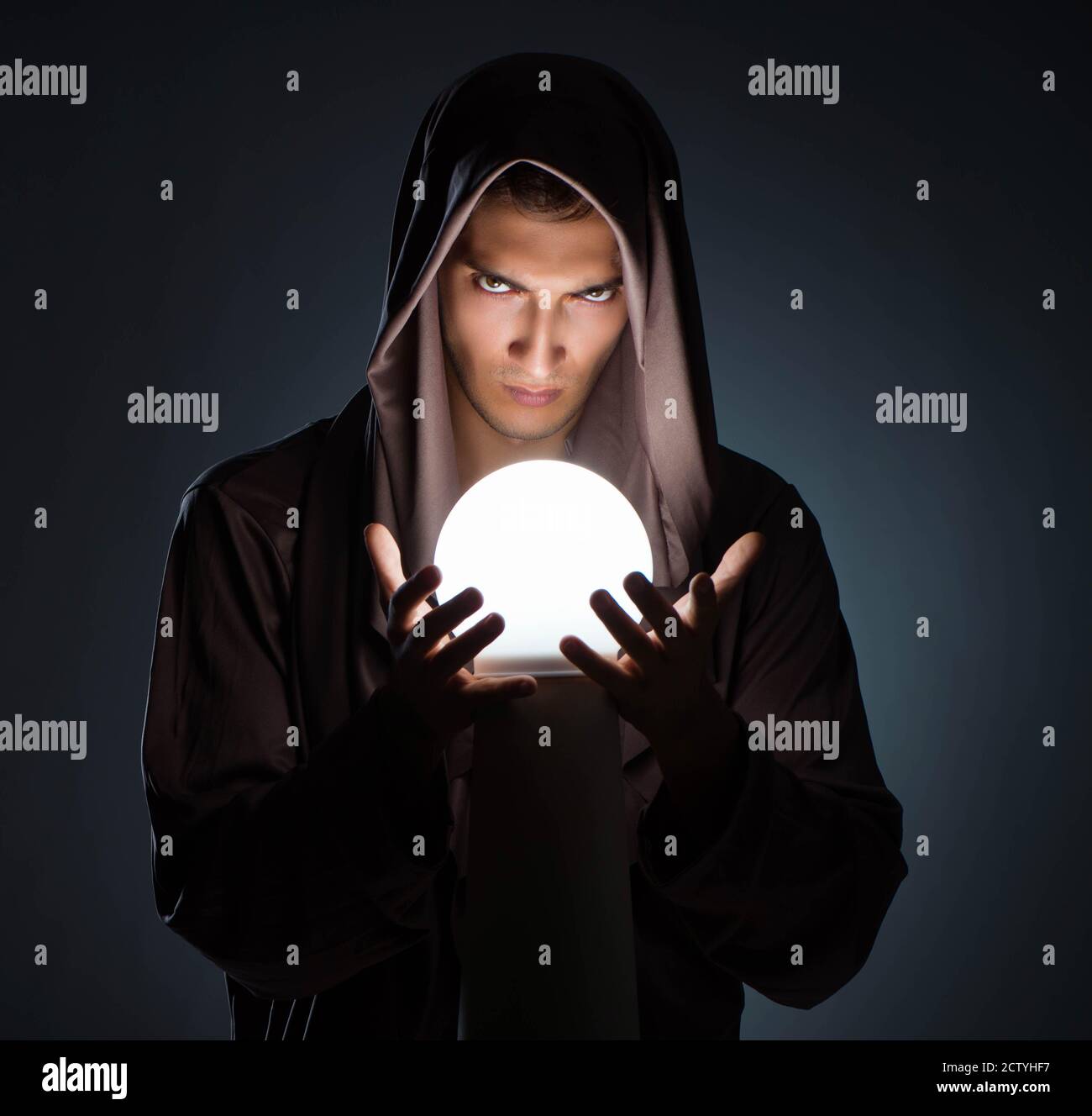 The young wizard with crystal ball in dark room Stock Photo - Alamy