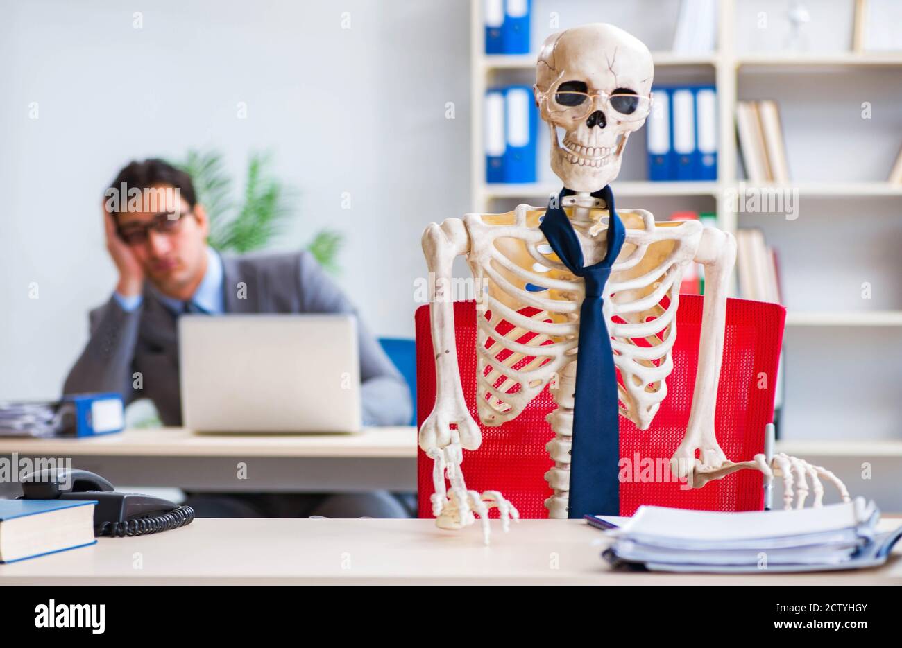 The businessman working with skeleton in office Stock Photo - Alamy