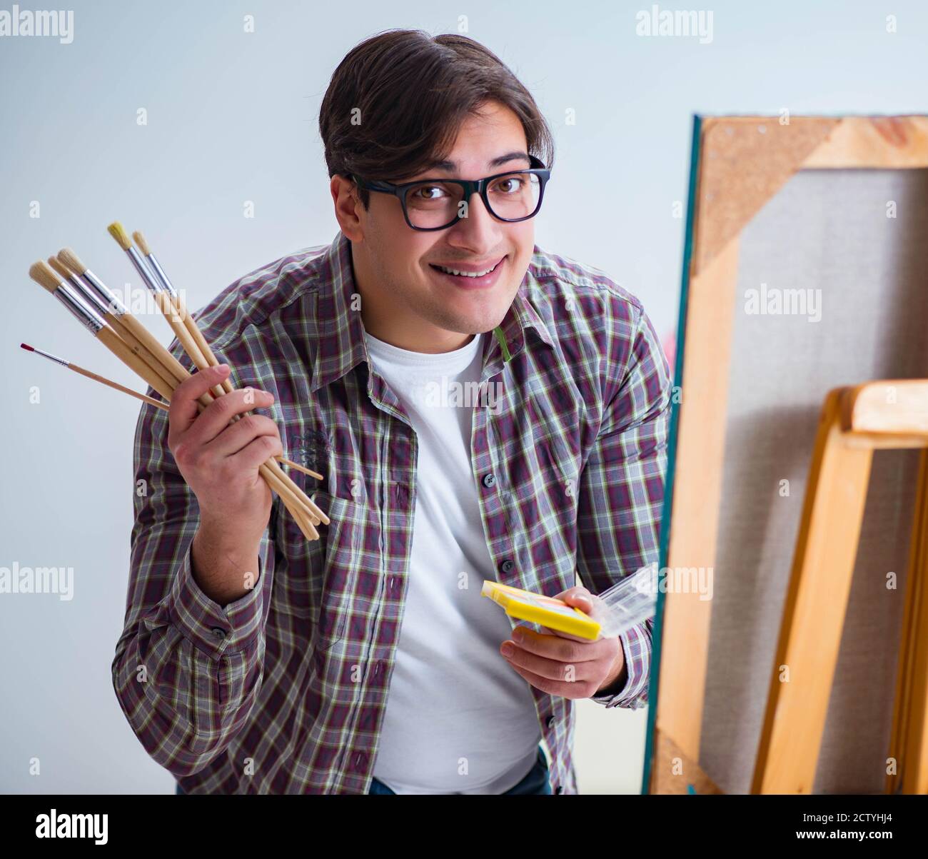 The young male artist drawing pictures in bright studio Stock Photo - Alamy