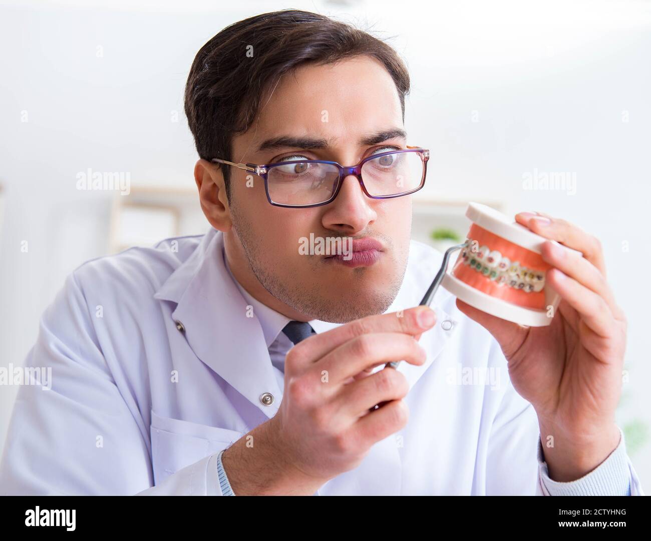 The funny dentist with teeth model in hospital Stock Photo - Alamy