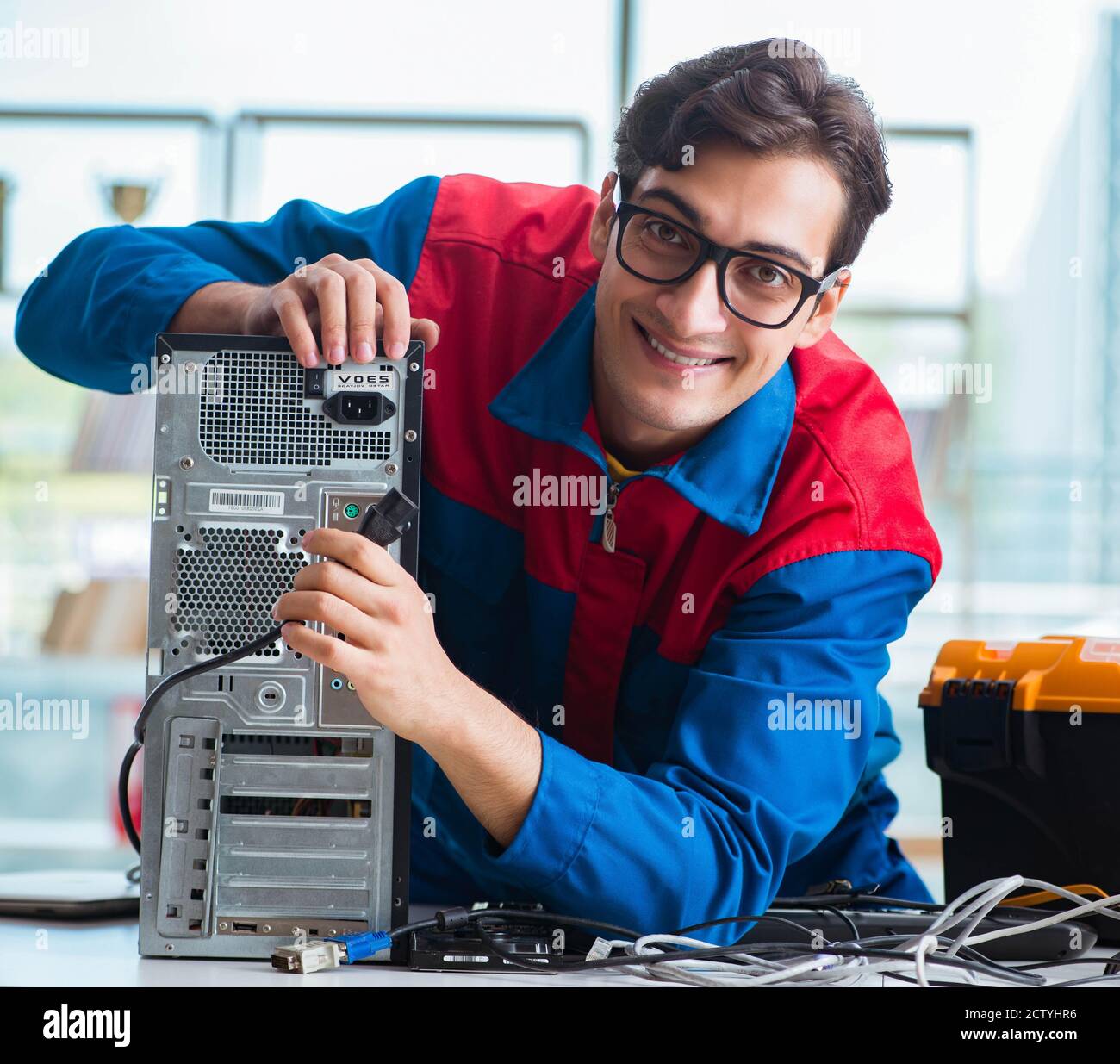 The computer repairman working on repairing computer in it workshop ...