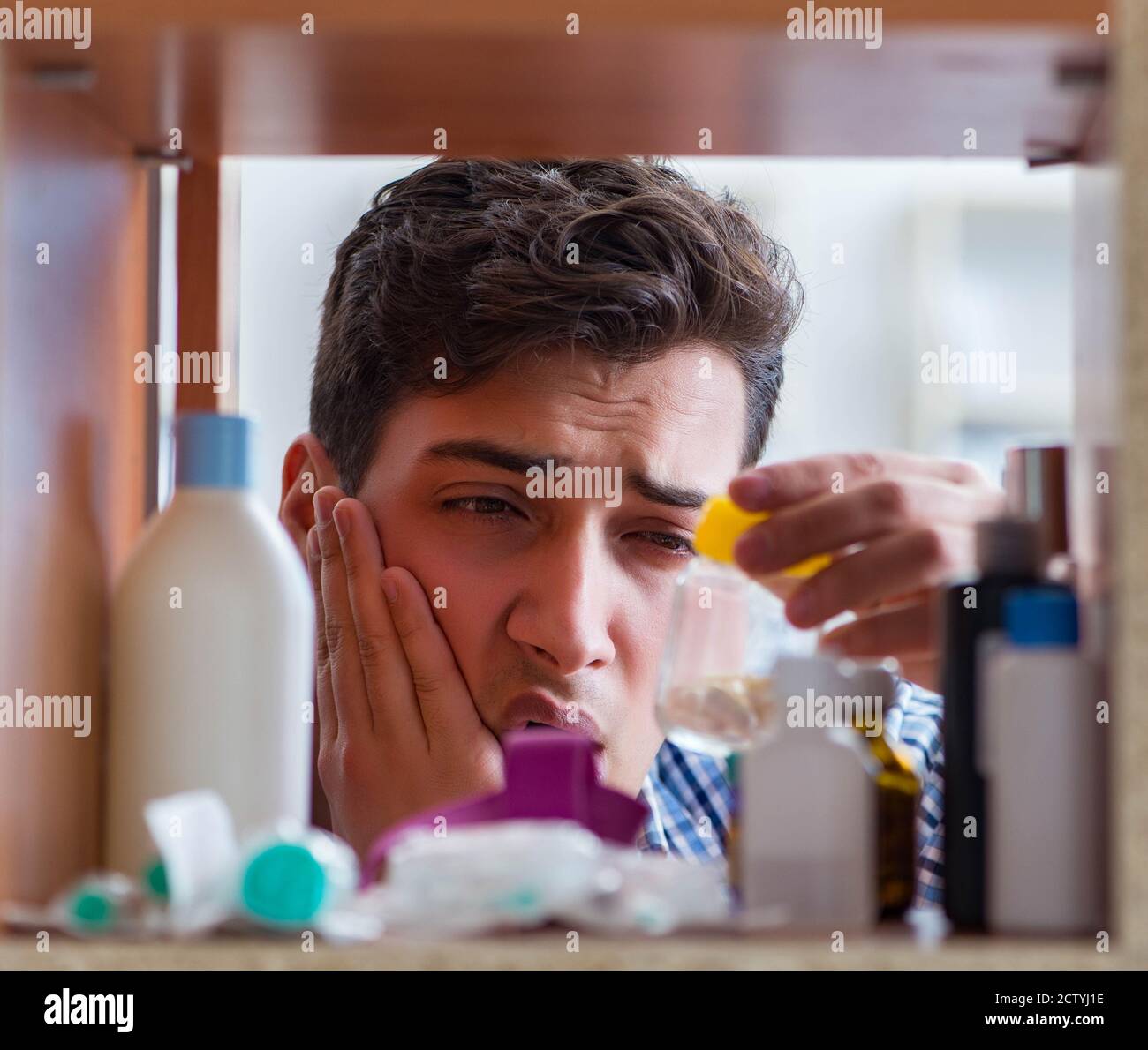The sick ill man looking for medicines at farmacy shelf Stock Photo - Alamy