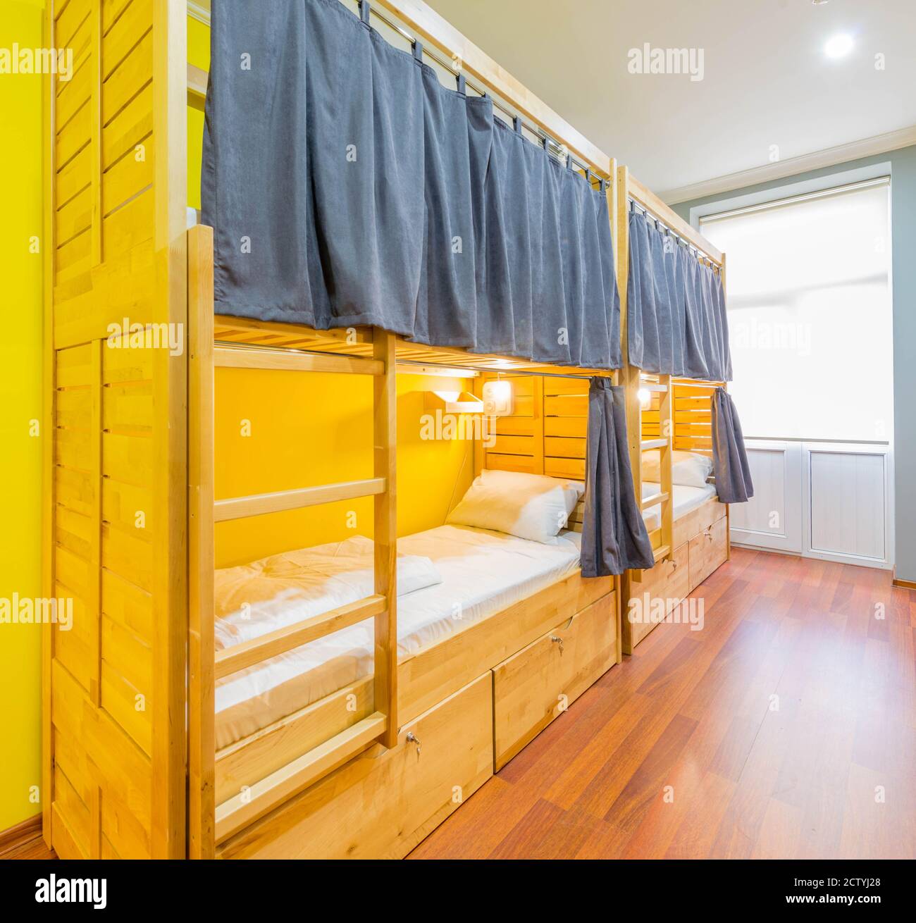 The hostel dormitory beds arranged in room Stock Photo - Alamy