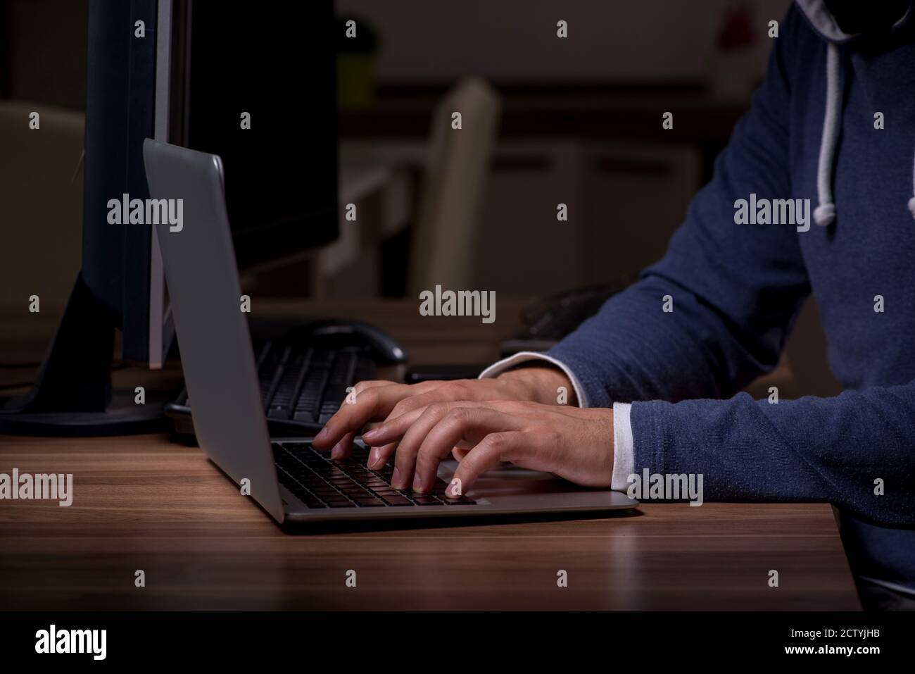Male hacker hacking security firewall late in the office Stock Photo ...