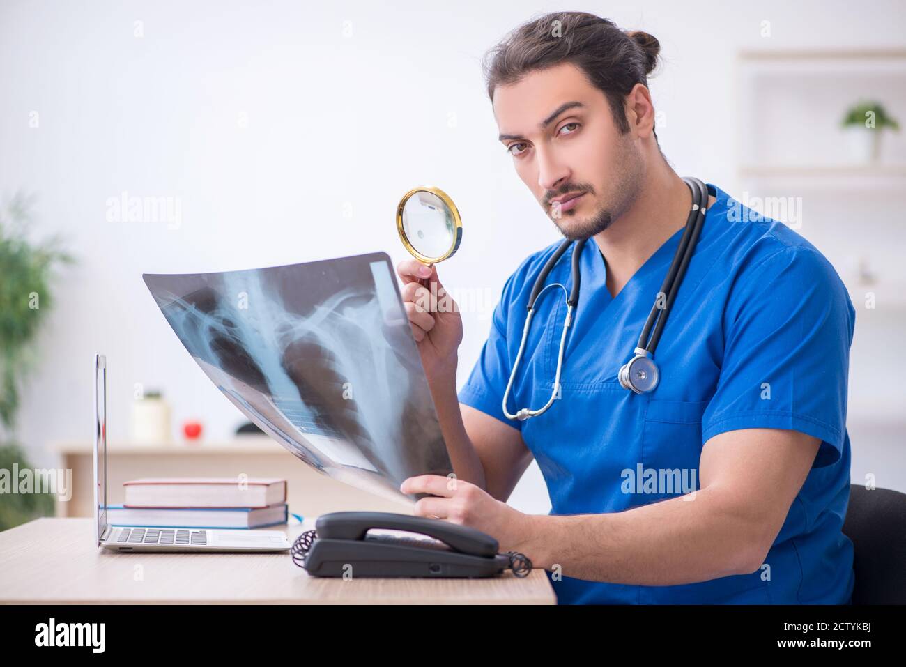 Young male doctor working in clinic Stock Photo - Alamy