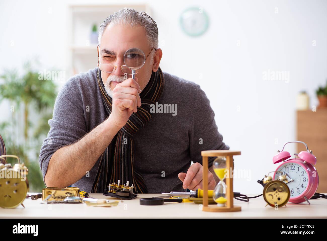 Old watchmaker working in the workshop Stock Photo - Alamy