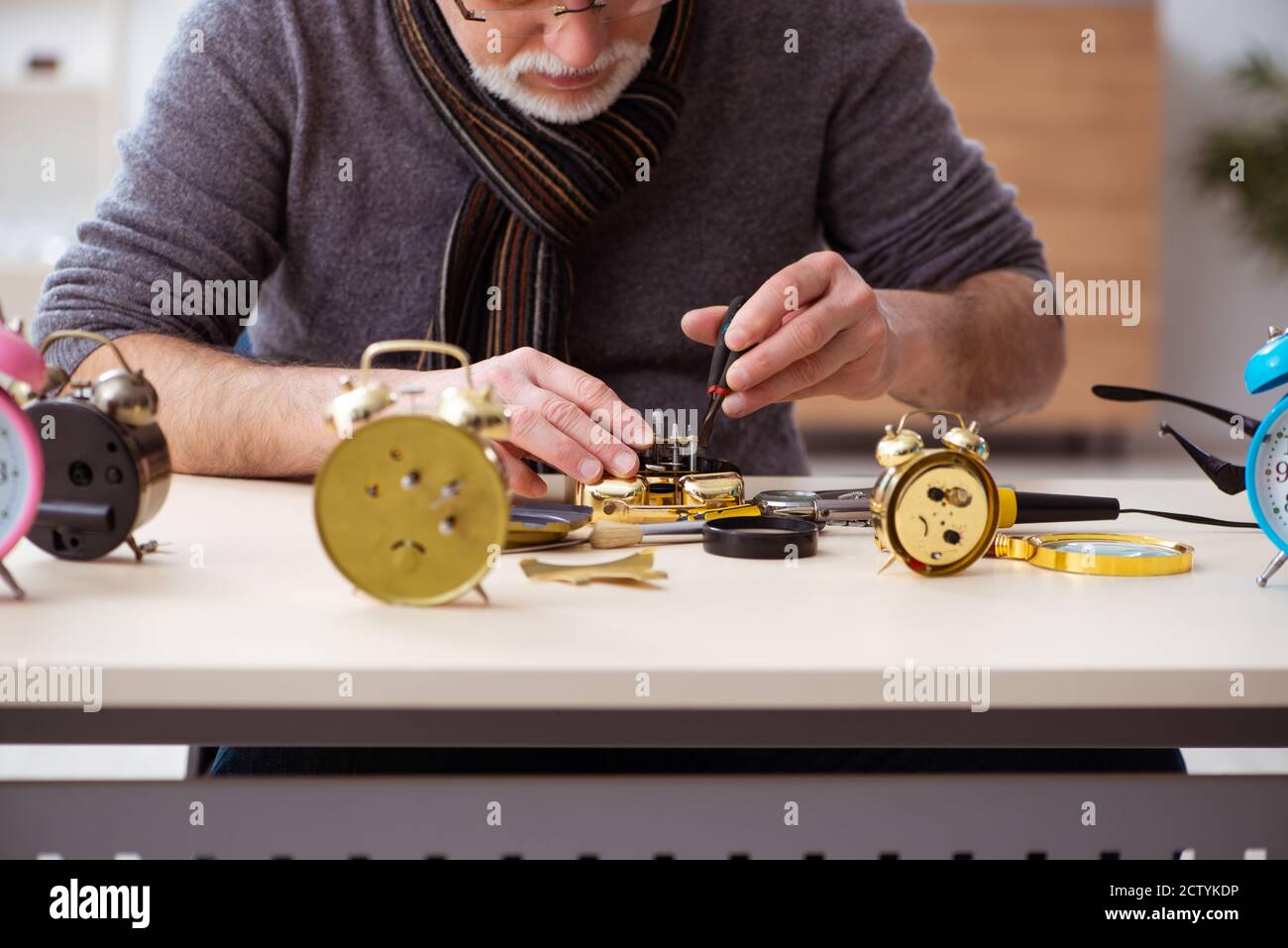 Old watchmaker working in the workshop Stock Photo - Alamy
