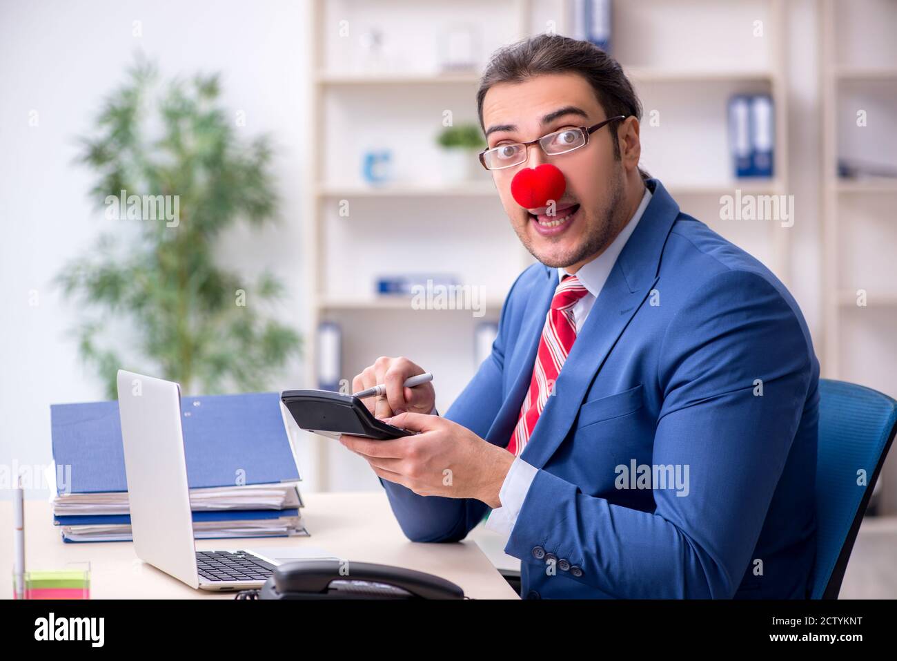 Funny employee clown working in the office room Stock Photo - Alamy