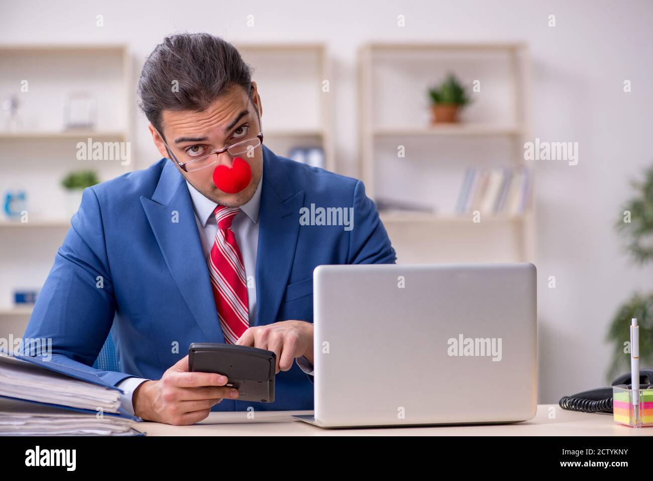 Funny employee clown working in the office room Stock Photo - Alamy