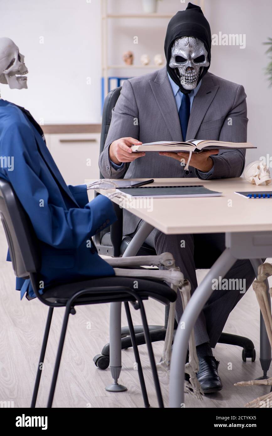 Funny business meeting with the devil and skeletons Stock Photo - Alamy